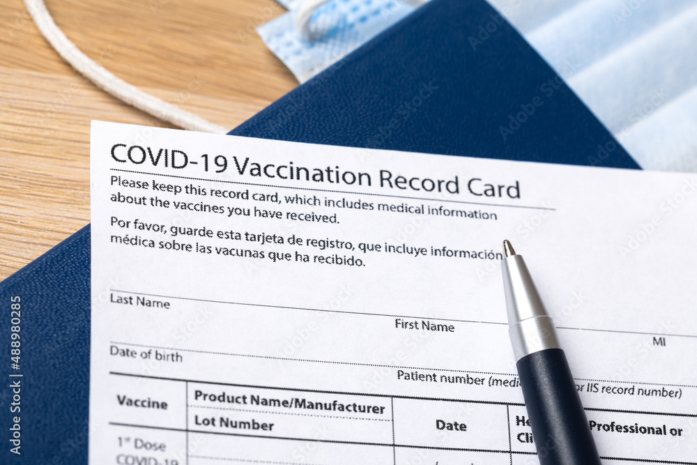 Coronavirus vaccination record card, biometric passport and blue ...