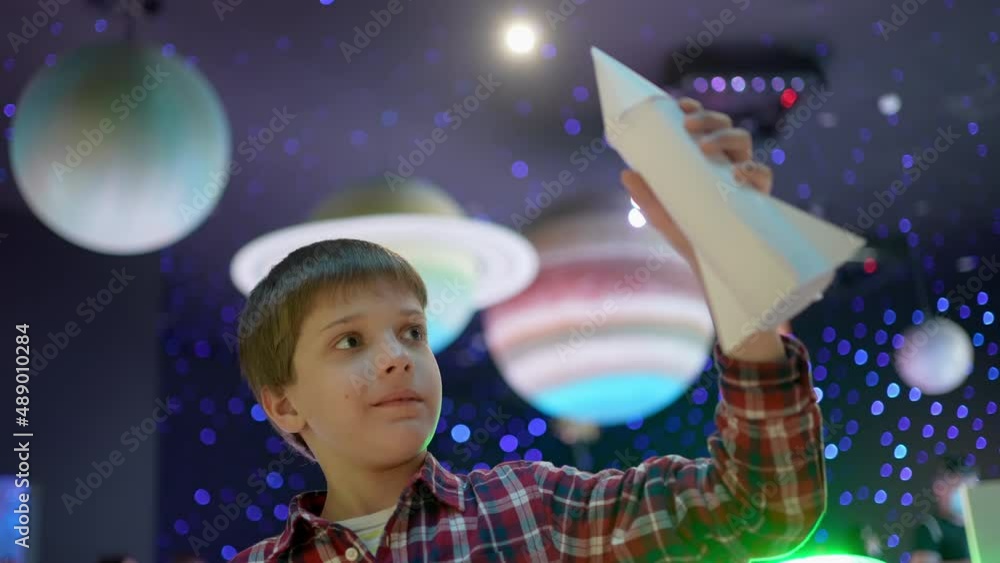 Happy cute boy dreaming flying toy astronaut rocket through planets at ...