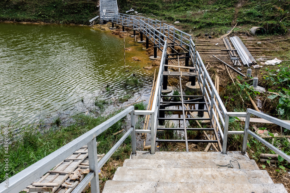 Construction of pedestrian bridge along the reservoir. The structure of ...