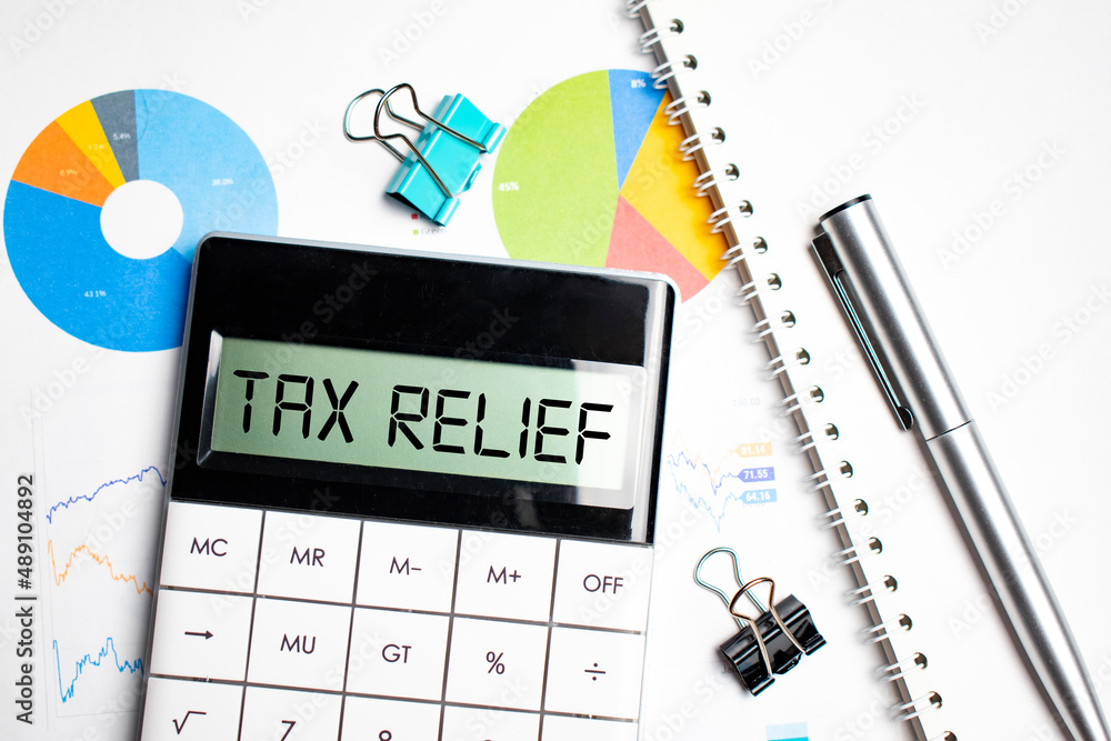 Word TAX RELIEF. Written on a calculator on an office desk. Stock Photo ...
