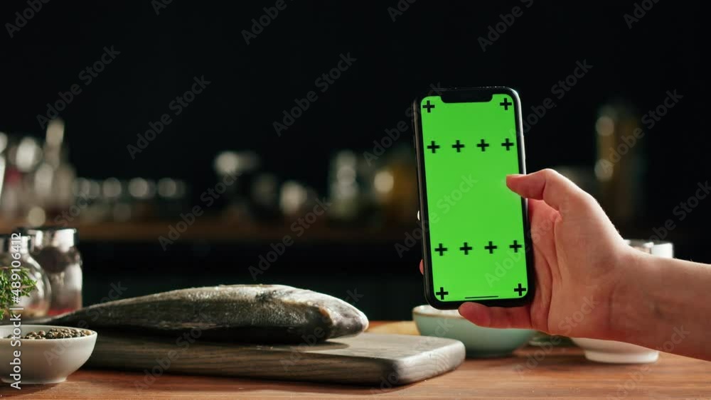 Cooking fish, woman using smartpgone with chroma key green screen ...
