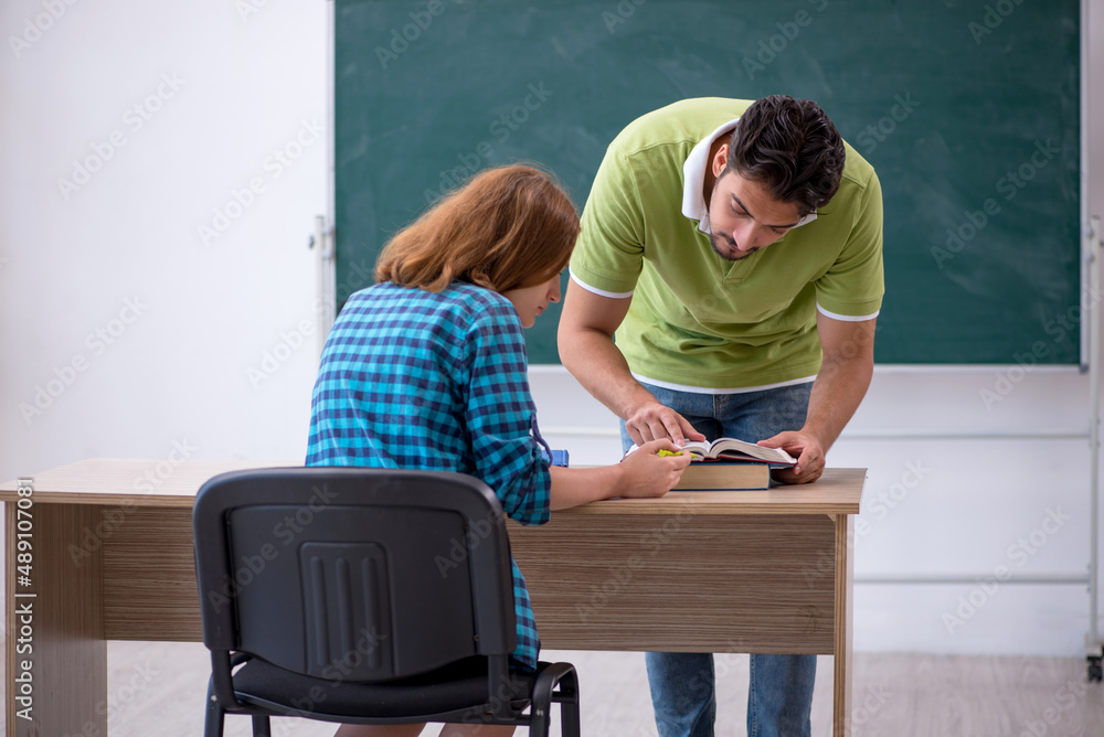 Young teacher and student in the classroom Stock Photo | Adobe Stock