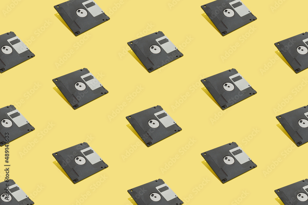 Seamless pattern made of vintage floppy disk drive on bright yellow ...