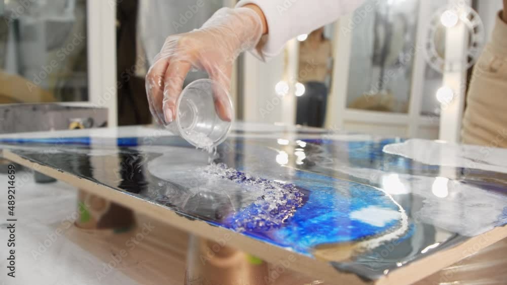 Adding texture with clear pieces to an epoxy resin painting Stock Video ...