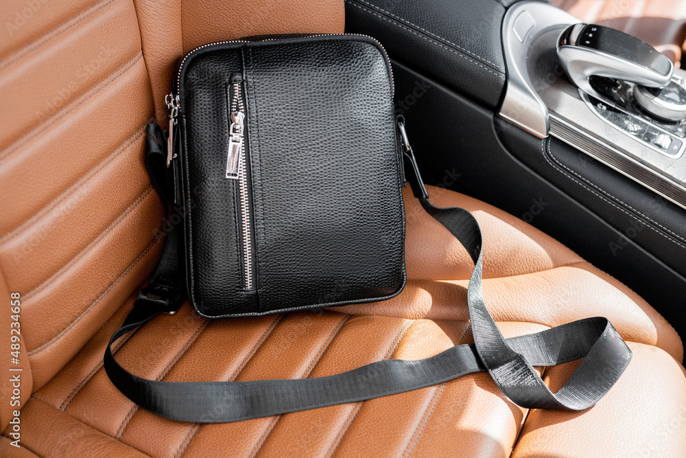 Stylish black business men's leather bag on the passenger seat next to ...