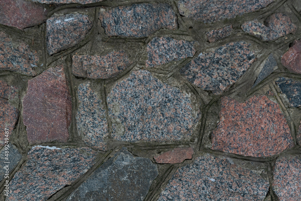 Part of a textured stone wall, with a beautiful texture of wild stone. Part of the masonry walls ...