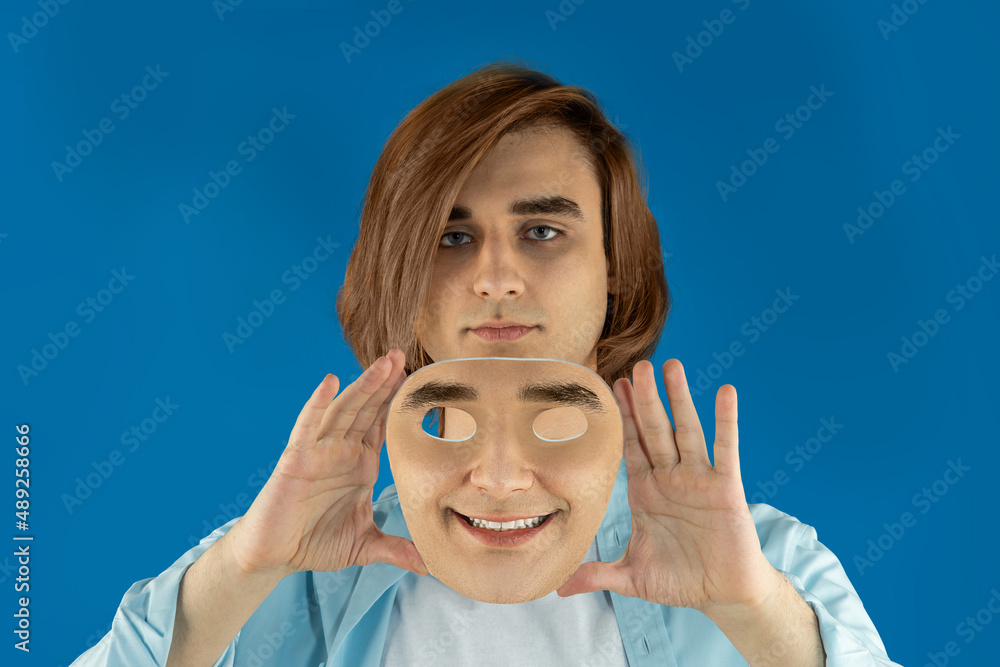 Mental health concept. Young man holding a full-face mask, ball, or ...