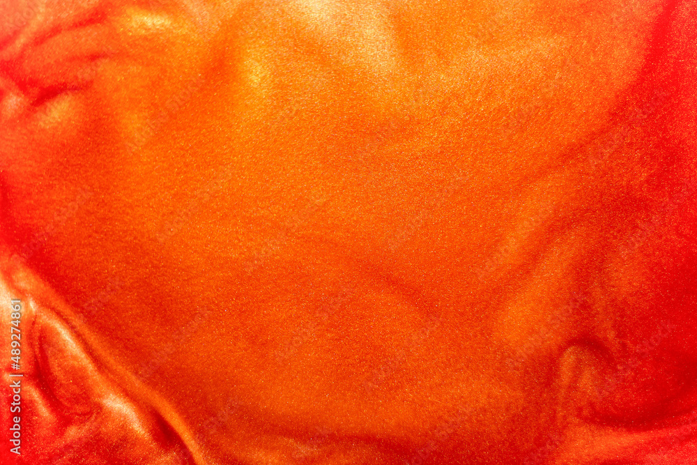 Defocus. Shiny particles of red, orange bright color in the water ...