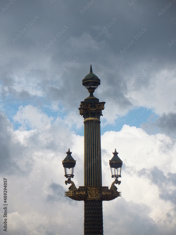 French 1830s ancient street lamp post against the sky at the end of ...