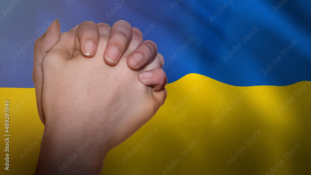 Pray for Ukraine message with a hand in prayer and the Ukrainian flag ...