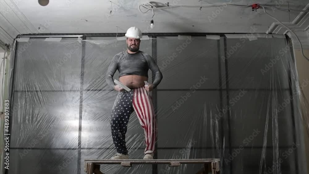 Video Stock Fat bearded adult man in protective helmet and USA flag ...