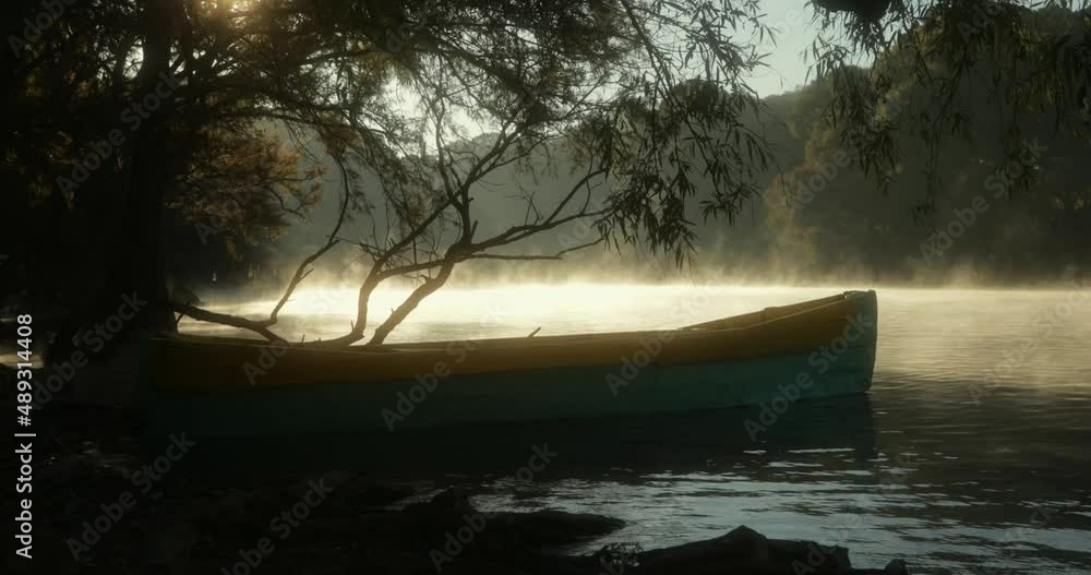 A boat floating in the sunrise on a beautiful lake. The sun's rays ...