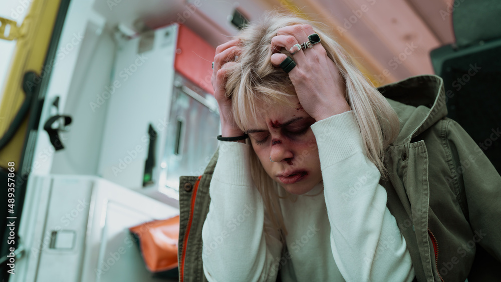Caucasian Female Holding On To Her Head As She Sits At The Back of an ...