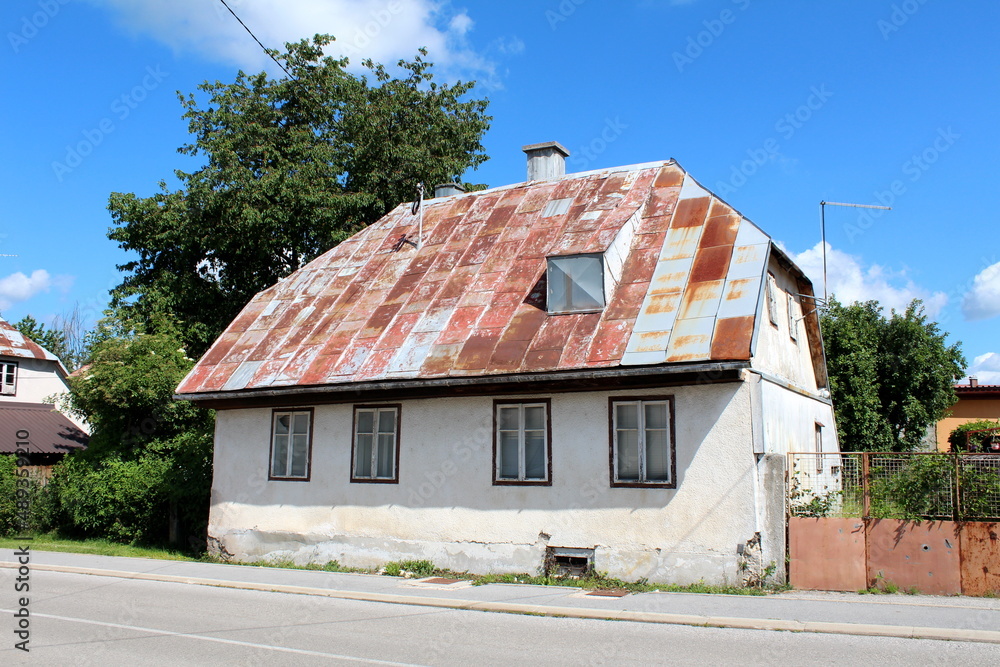 Traditional small old family house in rural area on concrete foundation with cracked facade ...