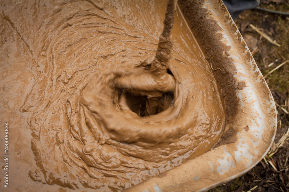 Building a House with Straw and Clay - mixing red clay with concrete ...
