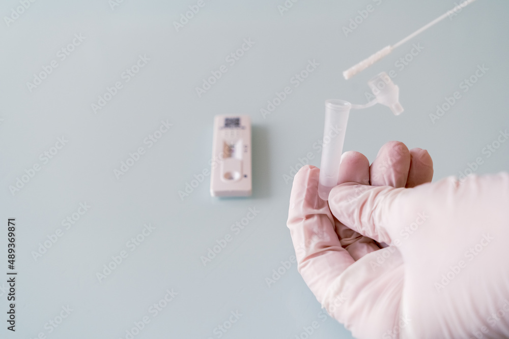 Person using a Covid-19 antigen test. Human hand with white glove ...