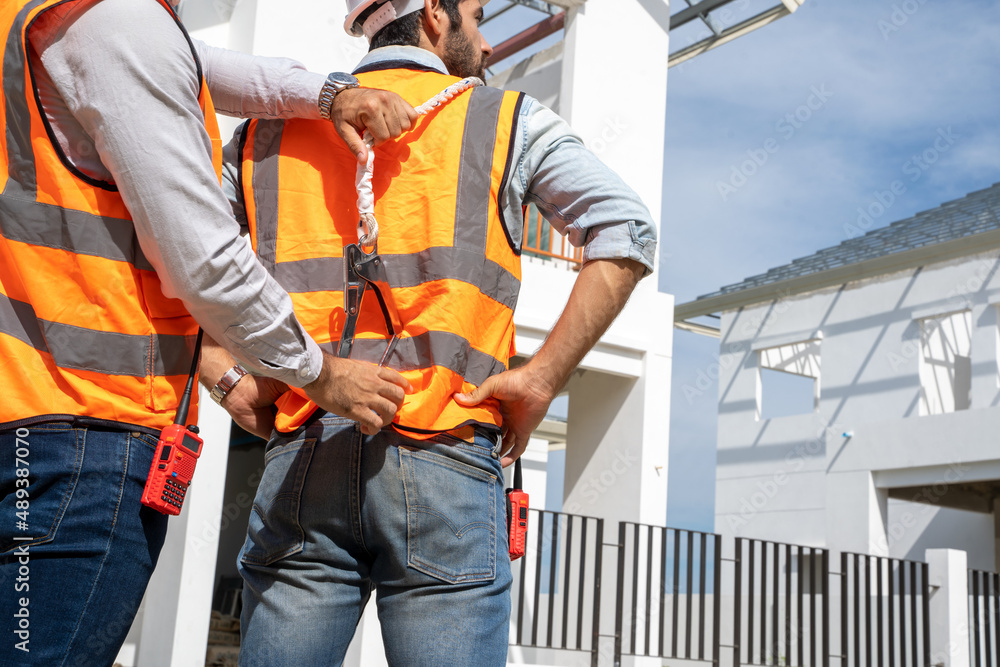 Construction worker wearing safety harness and safety line working at ...