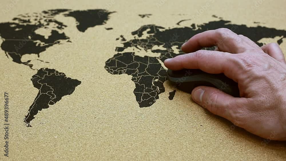 Computer mouse, mans hand close-up. Surface drawing of earth, countries ...