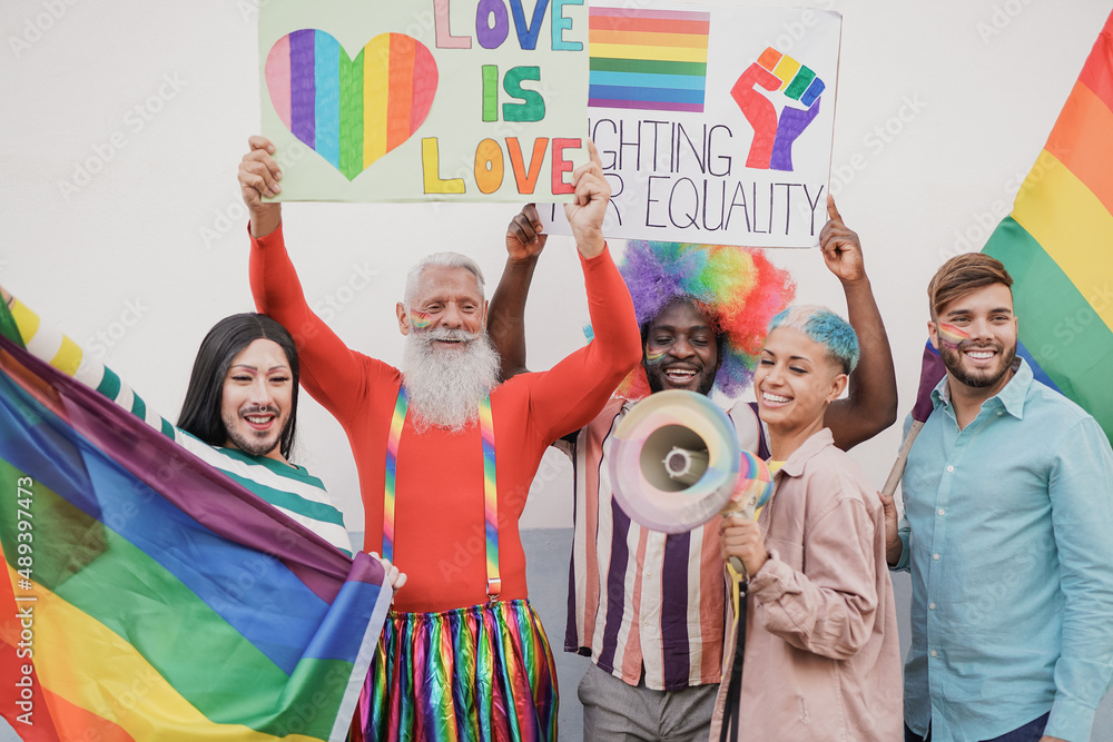 Happy diverse people having fun together at gay pride parade holding ...