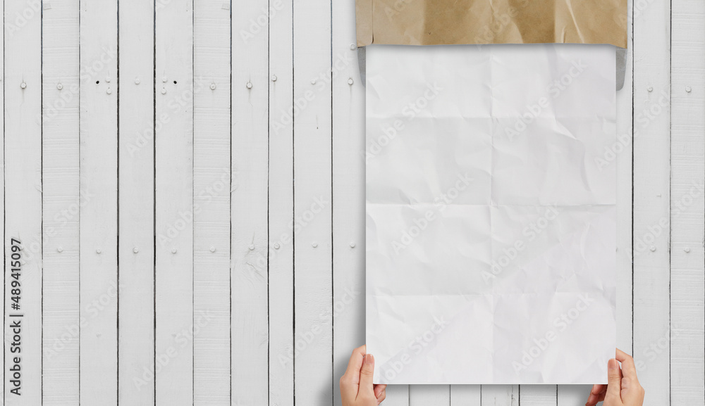 hand pulling crumpled paper from recycle envelope on white wood ...