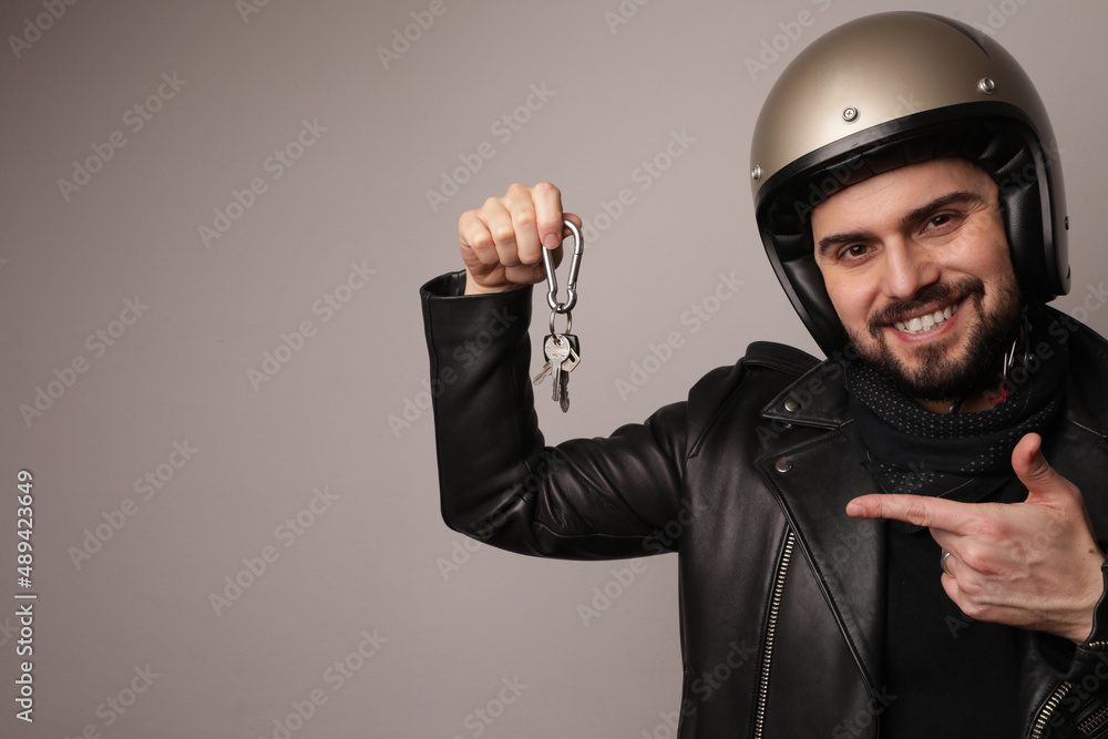 Happy biker men holds motorcycle keys wearing leather jacket and retro ...