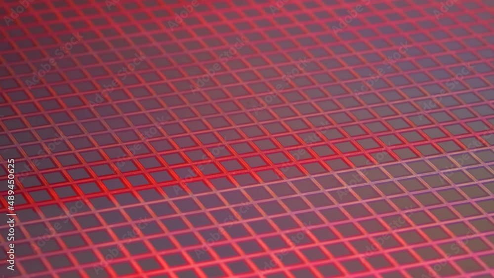 Silicon wafer with integrated circuits reflects red color. Modern ...