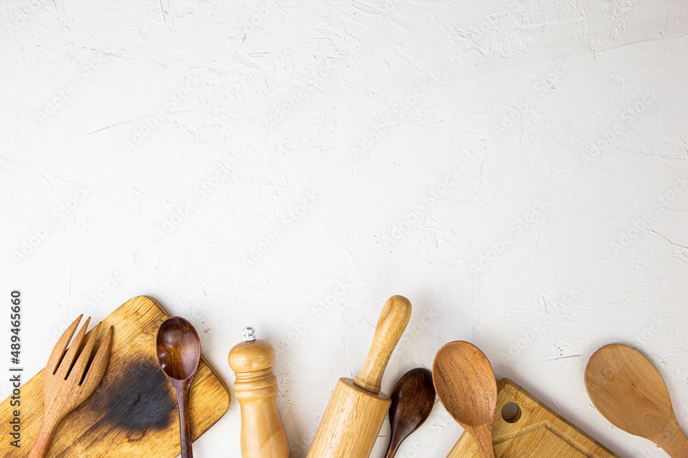Wooden table, white kitchen set and cooking equipment / Top view with ...