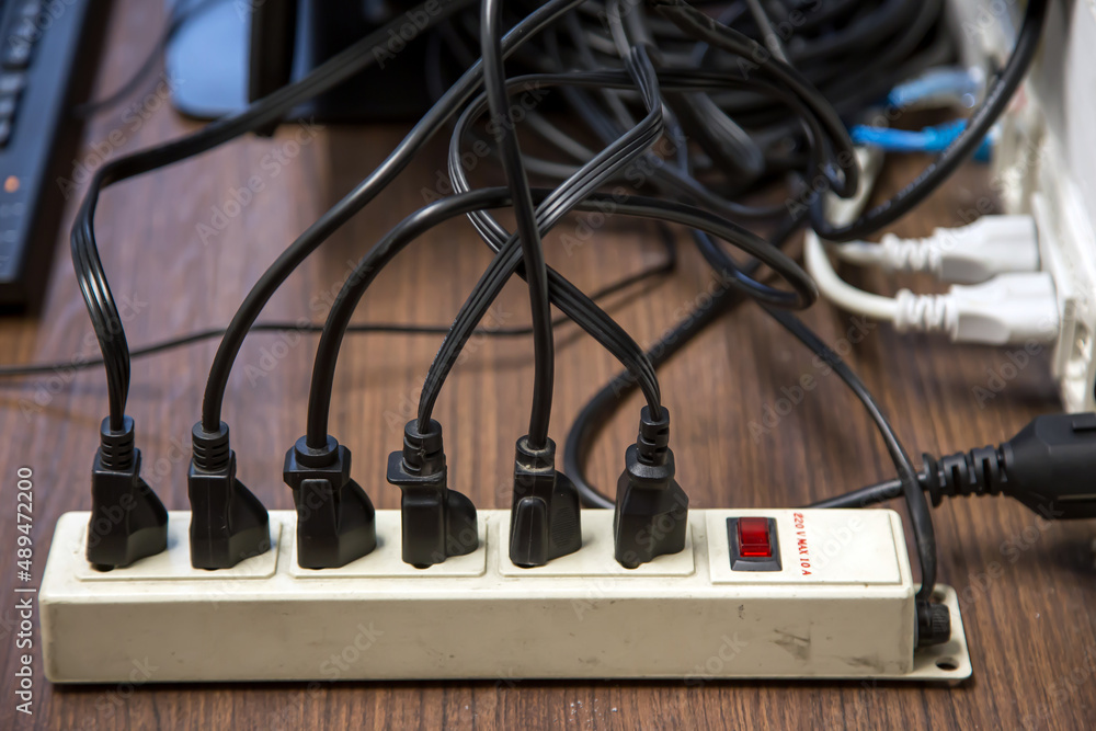 Foto de Old and damaged electric adapter power plug has many appliances ...