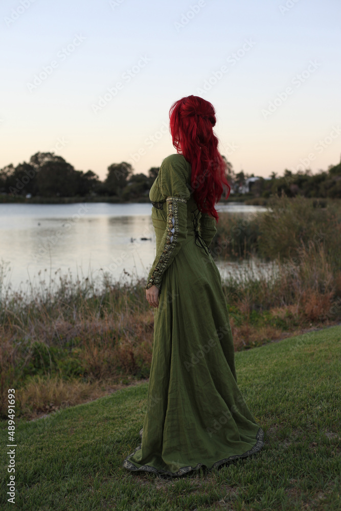 Full length portrait of red haired woman wearing a beautiful green ...