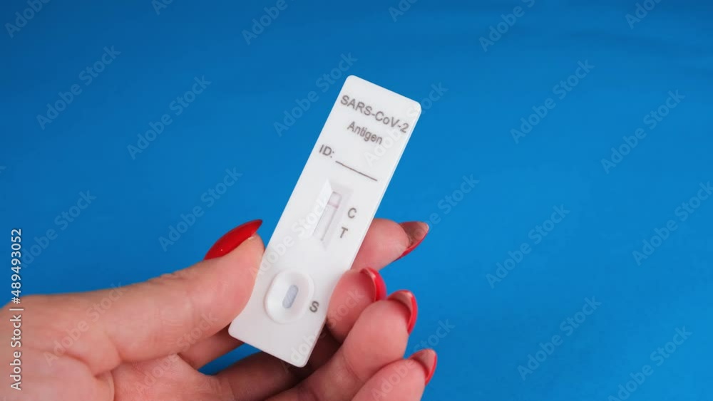 Female hand holding Negative SARS-CoV-2 Rapid Antigen Test on blue ...