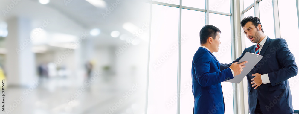 Two business people talk project strategy at office in widen view ...