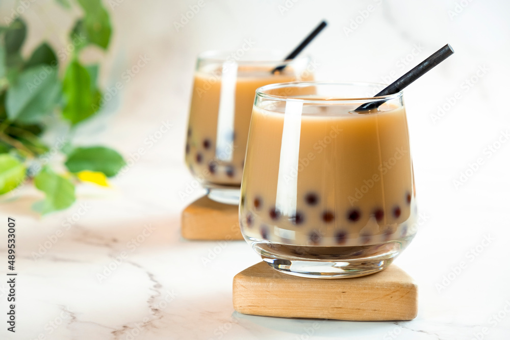 Two glasses with milk bubble tea with delicious tapioca pearls, green ...