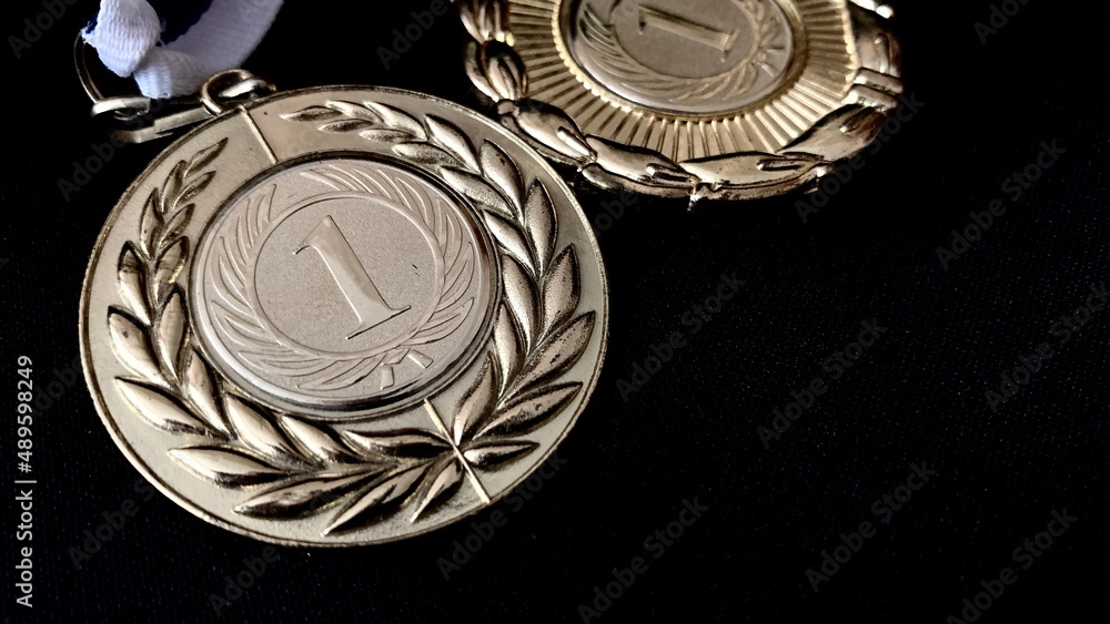 Gold, silver, bronze medals and cups on a black background. A large ...