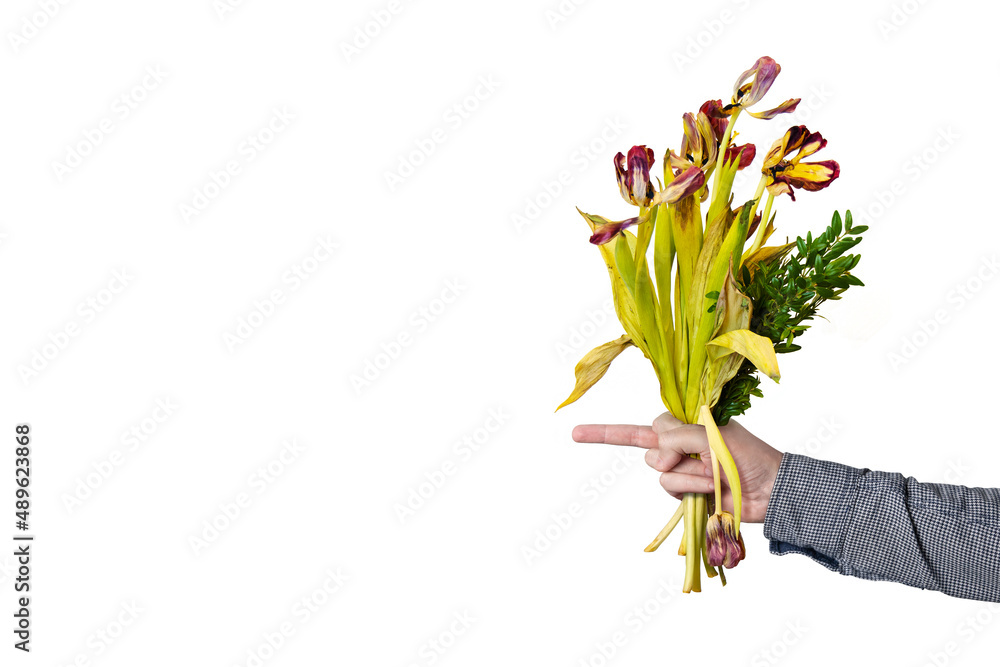 A bouquet of dried flowers in a man's hand with the middle finger ...