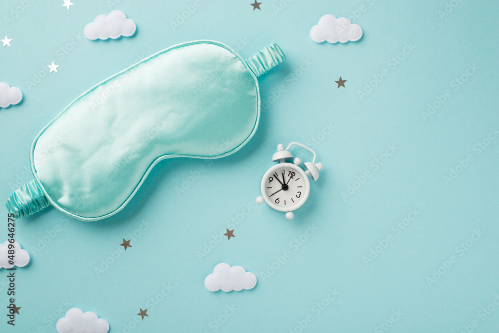 Top view photo of the big silk blue eye mask cute white clock and a ...