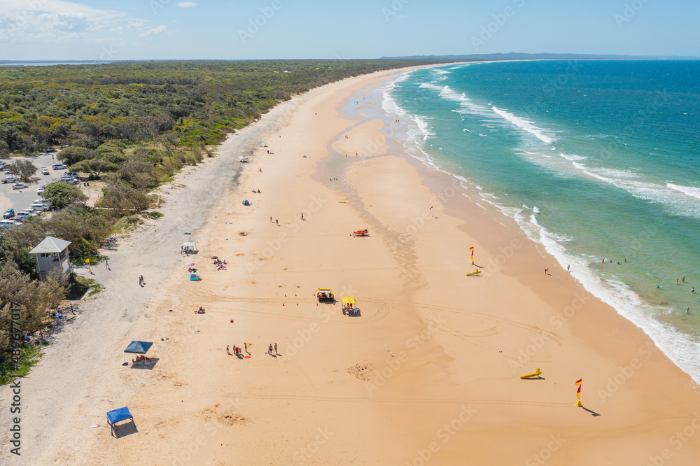 Aerial view of a wide sandy beach going off into the distance with ...