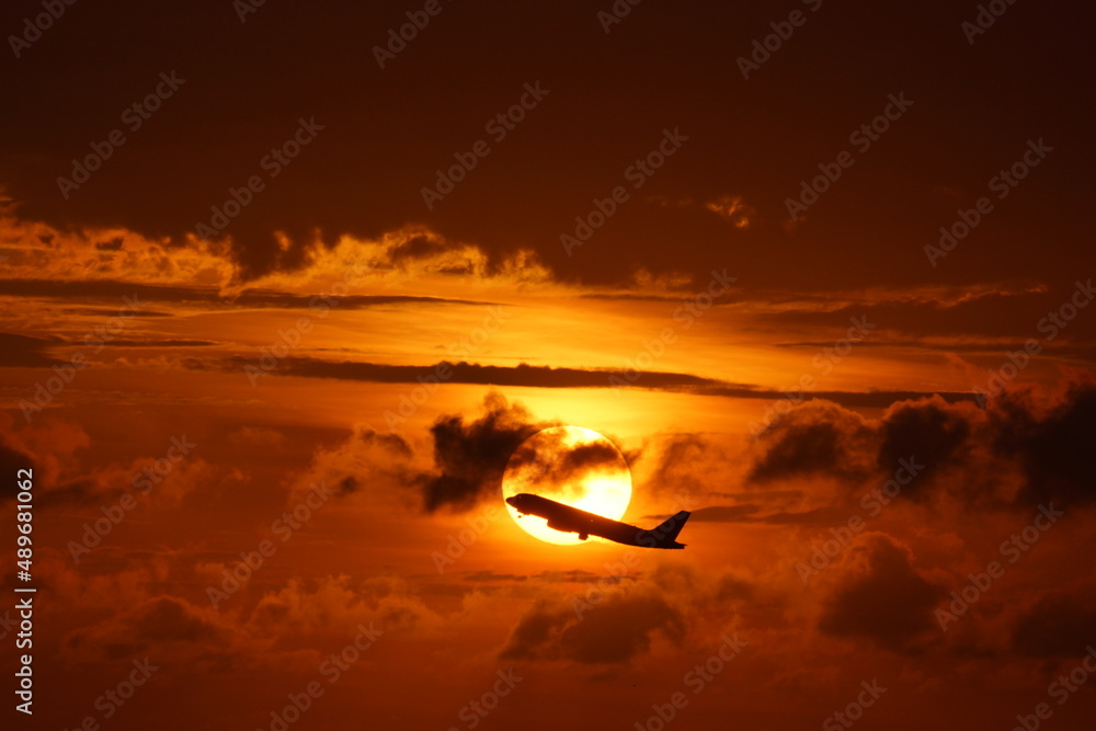 When the rising sun and rising plane cross paths Stock Photo | Adobe Stock