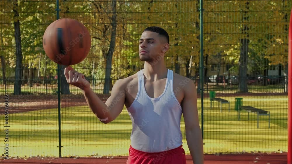 Man practicing to balance basketball ball on finger. Male player ...