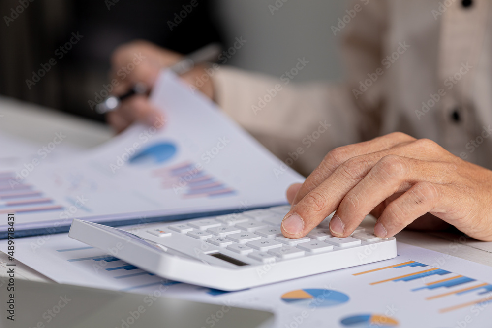 Business men using a calculator to calculate numbers on a company's ...