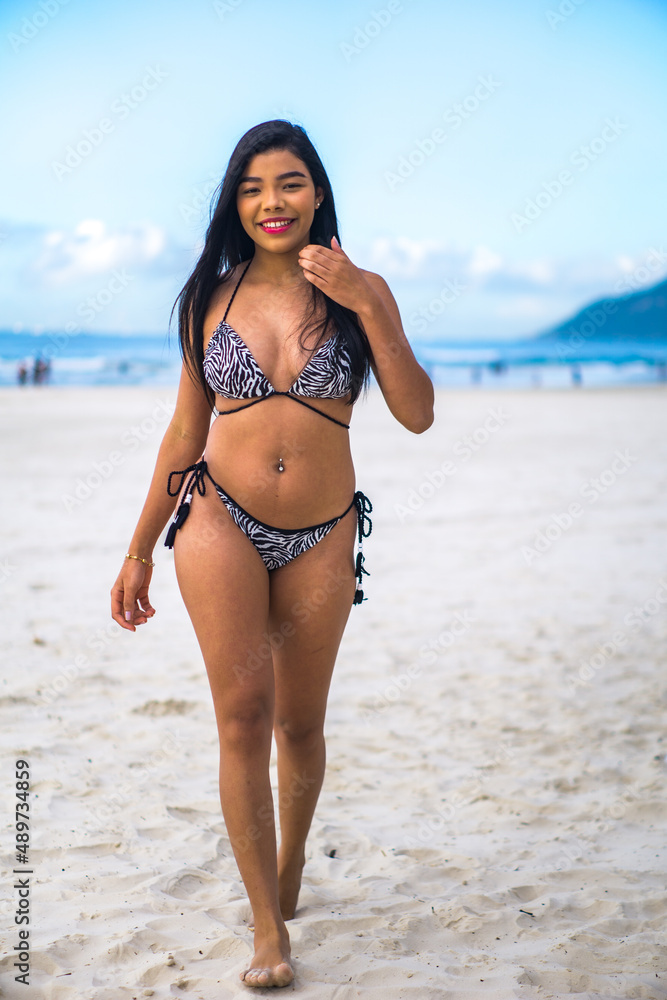 Foto de young beautiful and happy Asian Indonesian woman in bikini enjoying holidays at tropical ...