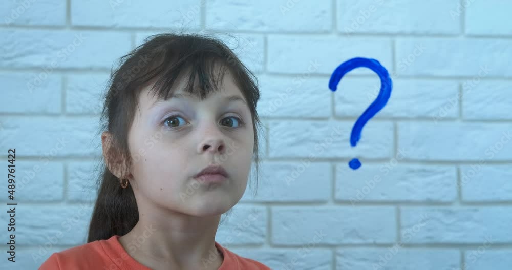 Child by drawn question mark. A pretty little girl stay by the drawn ...