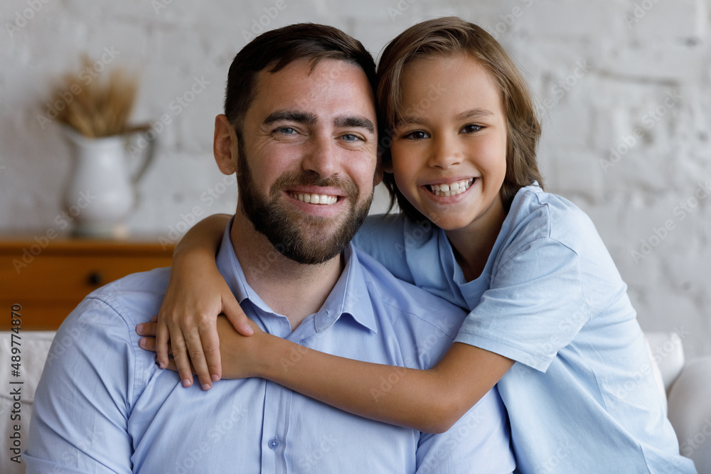 Portrait of handsome 35s dad and cute little 10s son. Smiling boy hugs ...