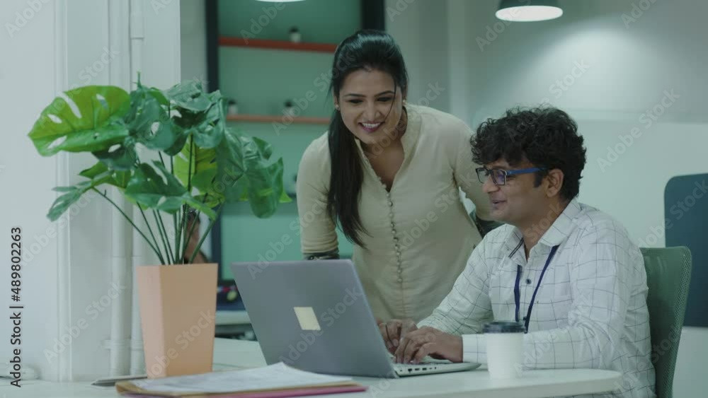 Two Indian businessman and women sitting in the office while talking ...