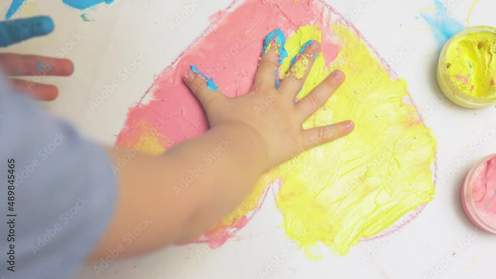 baby children drawing with finger paints pink heart white paper. mother ...