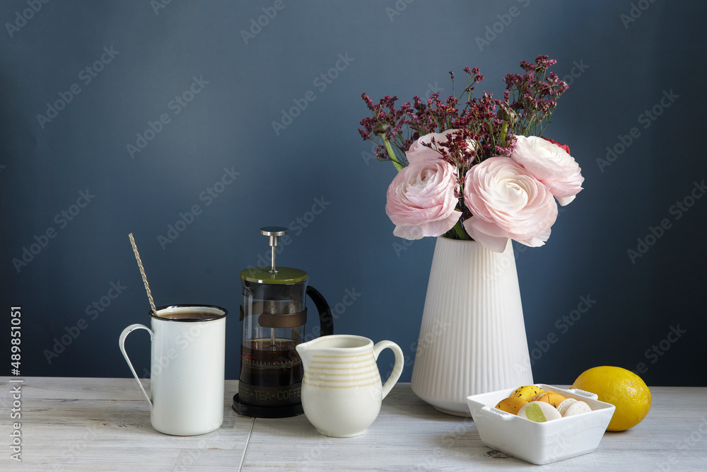 Coffee cup and bouquet of pink Persian buttercups on wooden table. mock ...