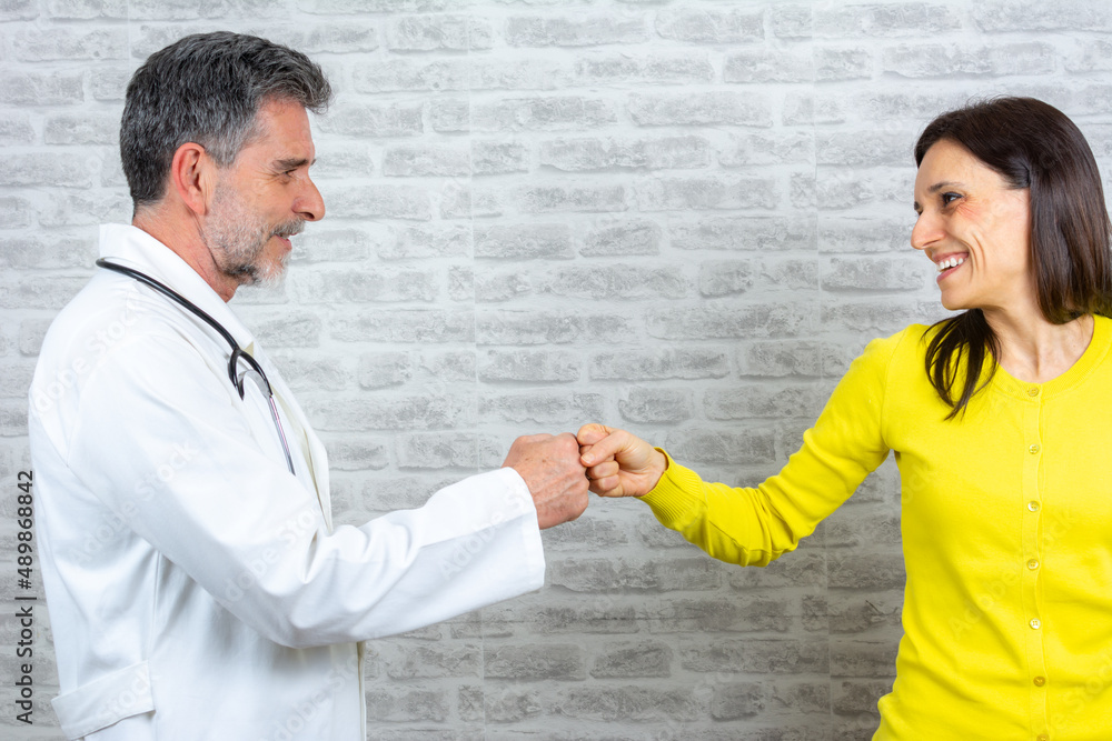 Doctor giving fist bump with patient woman in hospital. healthcare and ...