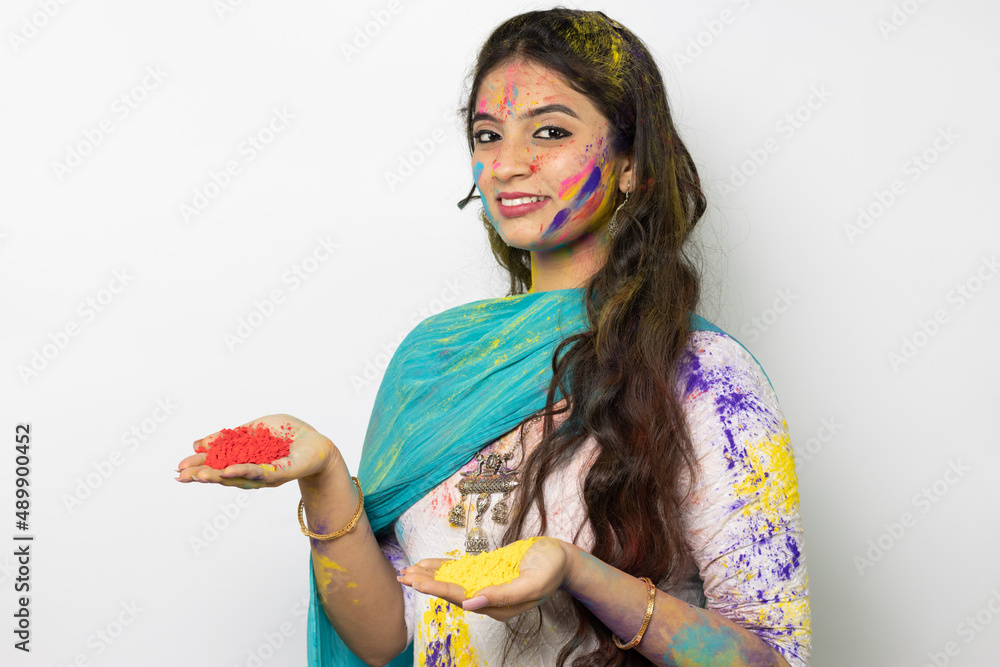 Young indian smart girl with color powder in her hand and with face ...
