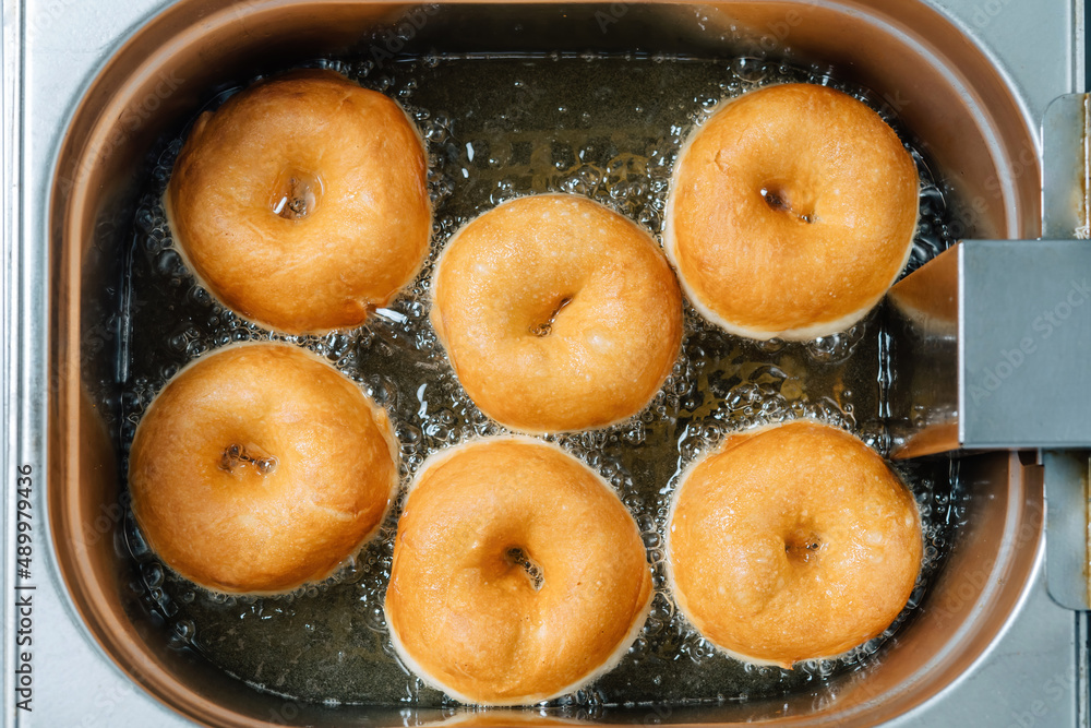 Donuts frying in deep fat. Preparation of traditional donuts, six round ...