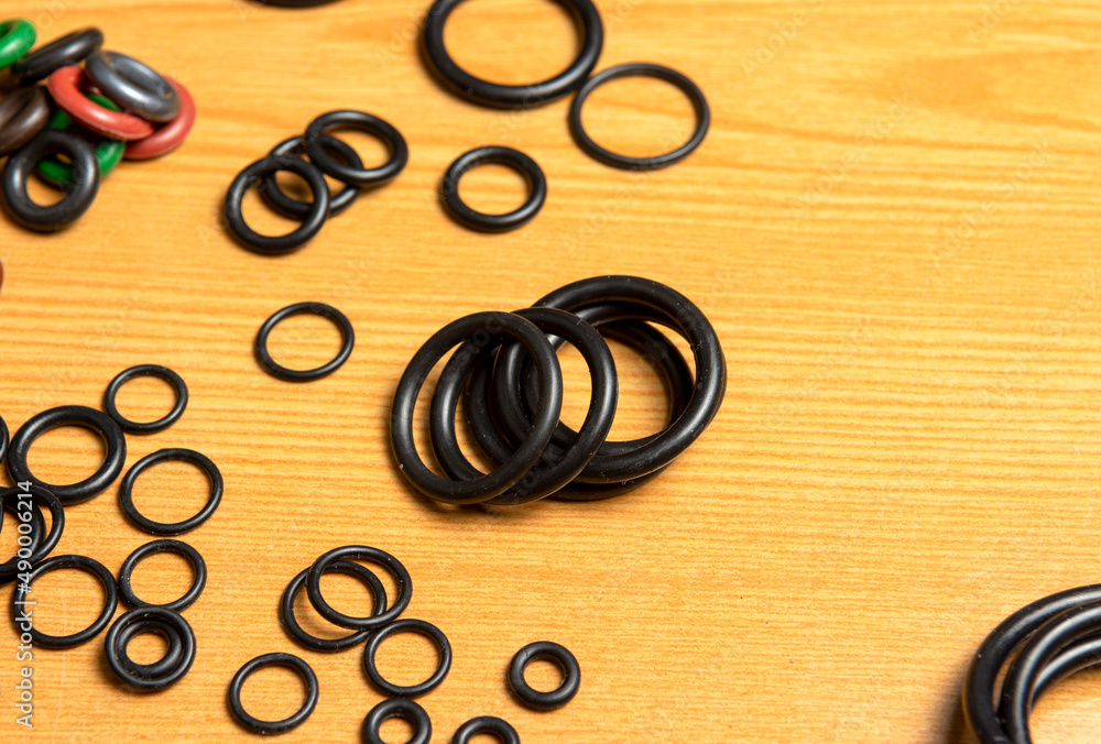 Black hydraulic and pneumatic o-rings in different sizes on a wooden ...