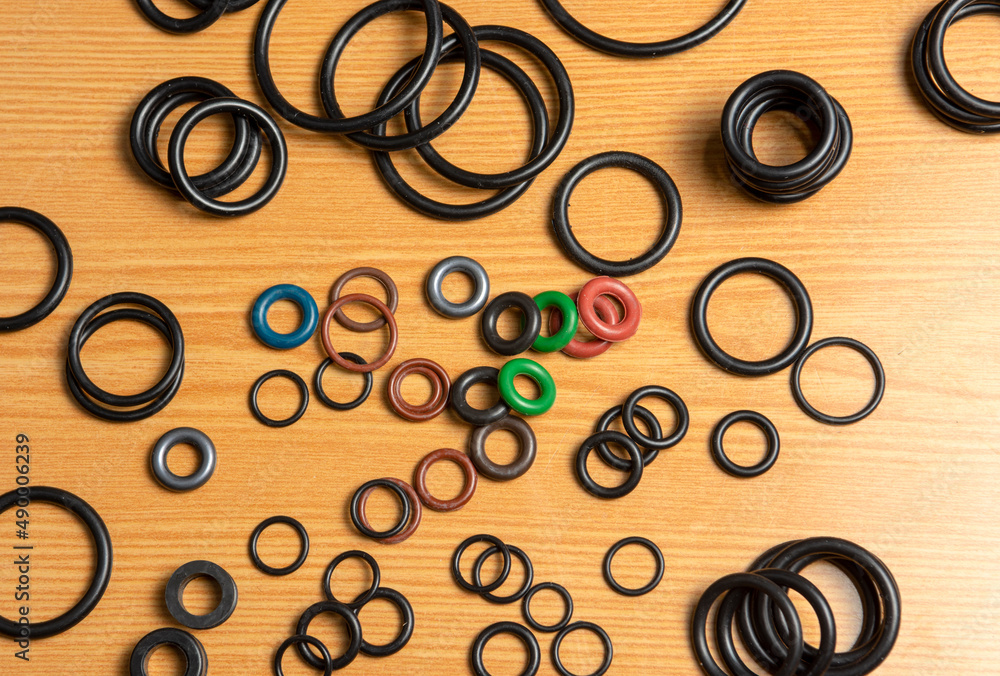 Black hydraulic and pneumatic o-rings in different sizes on a wooden ...